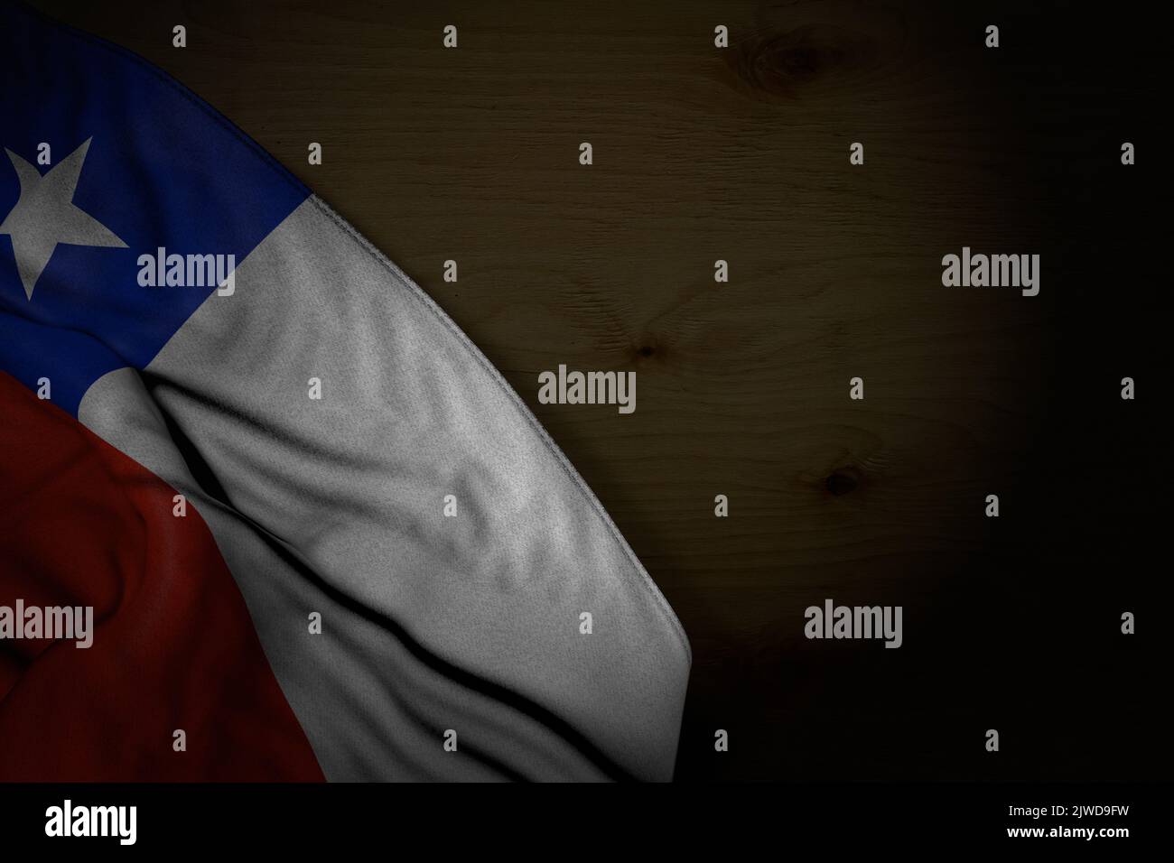 pretty dark picture of Chile flag with big folds on dark wood with ...
