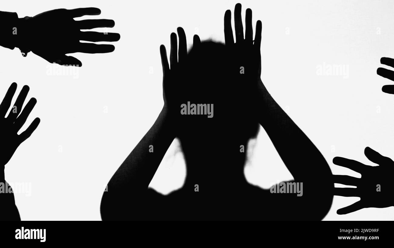 black shadow of bullied woman gesturing near hands of people isolated ...