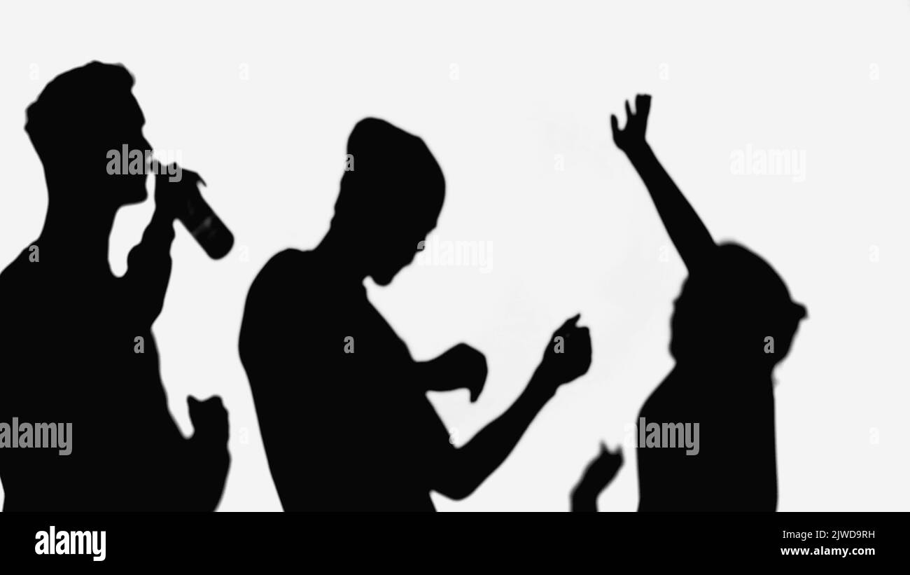 black shadows of friends dancing near man drinking beer isolated on ...