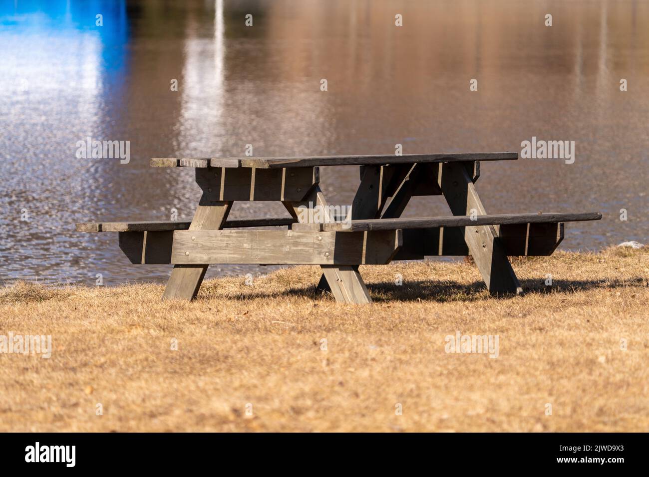 An old wooden picnic table on a lake shore Stock Photo - Alamy
