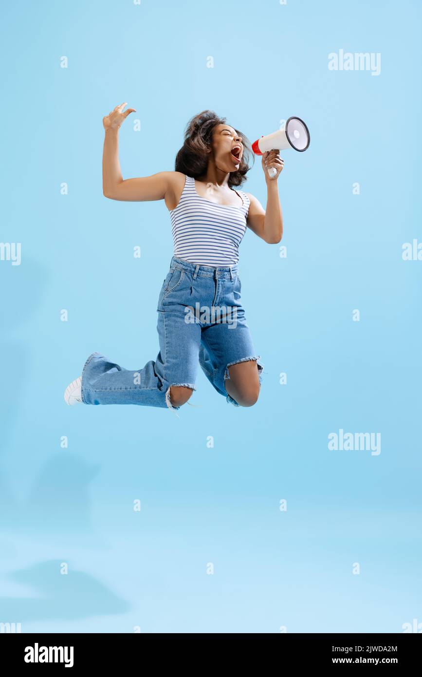 Excited young girl, student wearing casual style clothes jumping and ...
