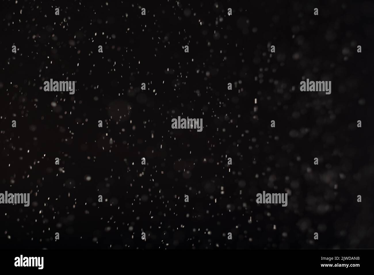 snowfall background blur flying white flakes black Stock Photo - Alamy