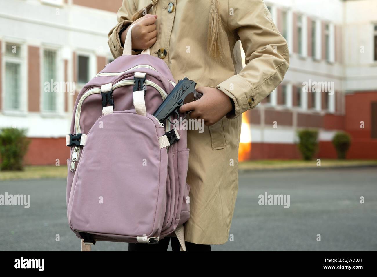 Firearms at school. Schoolgirl with a gun in a backpack on a school ...
