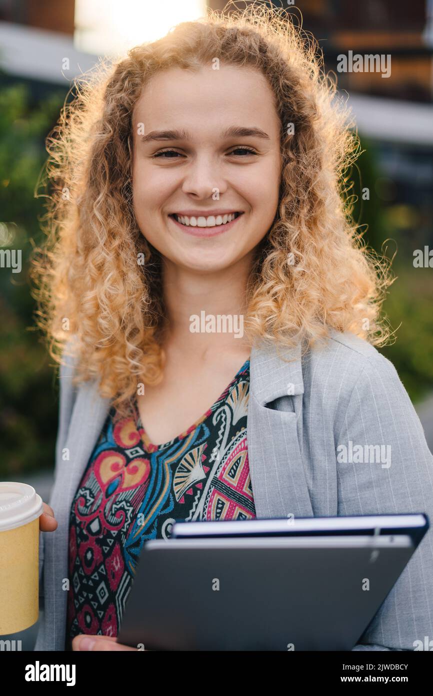 Front view portrait of a smiling caucasian woman student with curly ...