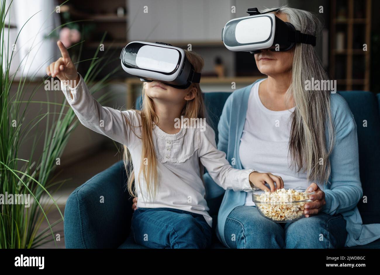 Cheerful european little granddaughter and old grandmother in vr ...
