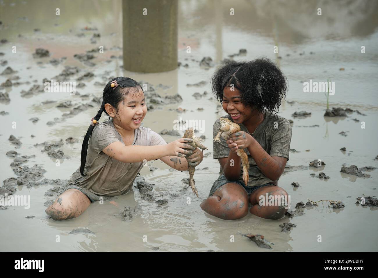 Group of kids playing on muck in the raining day Stock Photo - Alamy