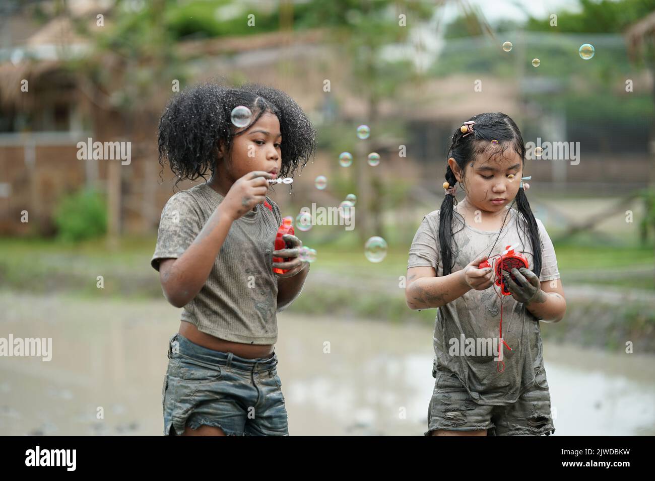 Group of kids playing on muck in the raining day Stock Photo - Alamy