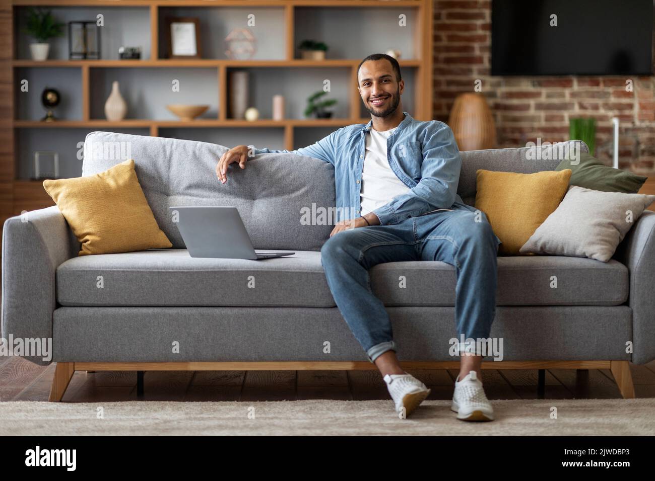 Handsome Black Man Sitting On Couch With Laptop And Smiling At Camera ...