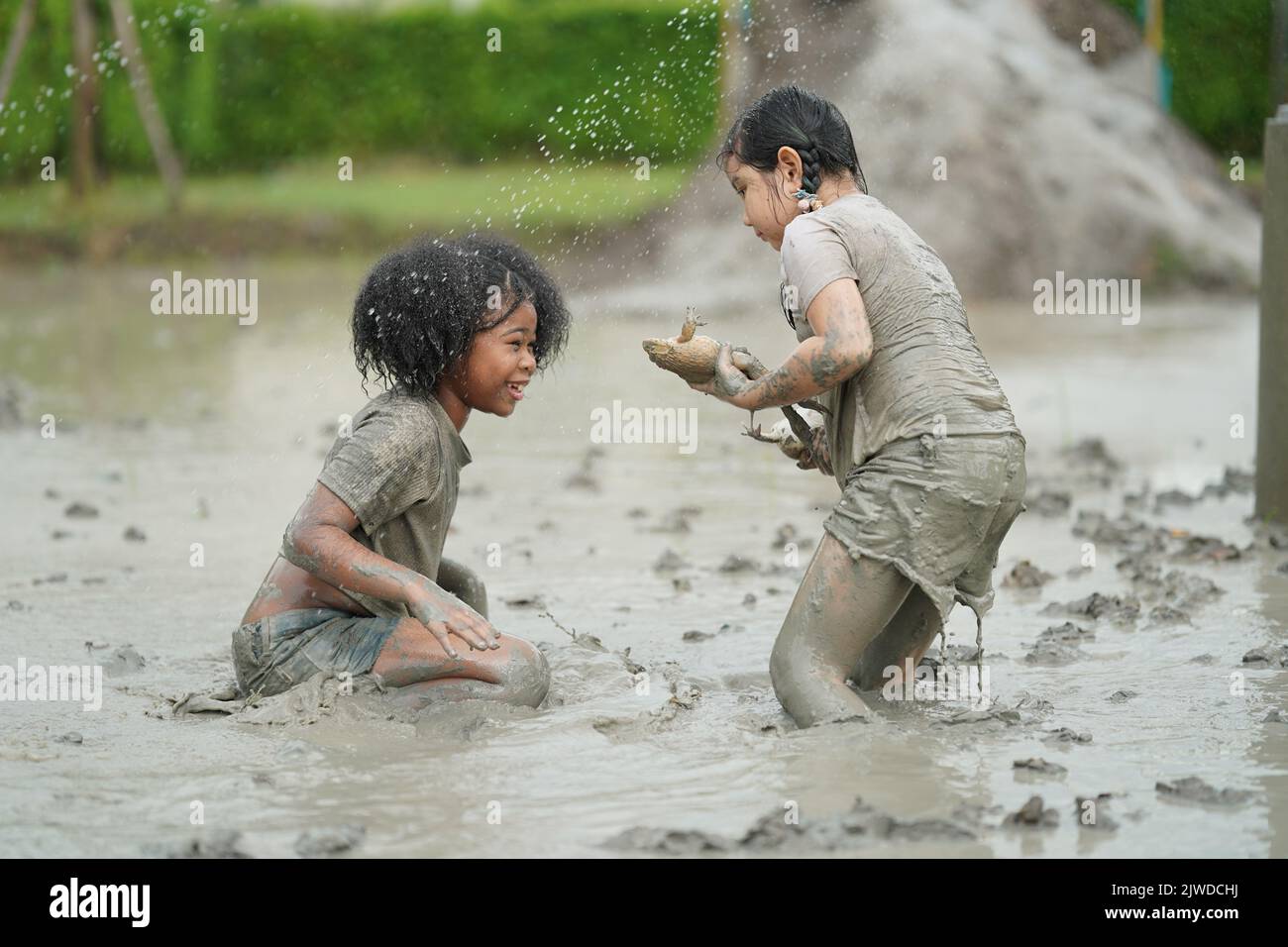 Group of kids playing on muck in the raining day Stock Photo - Alamy