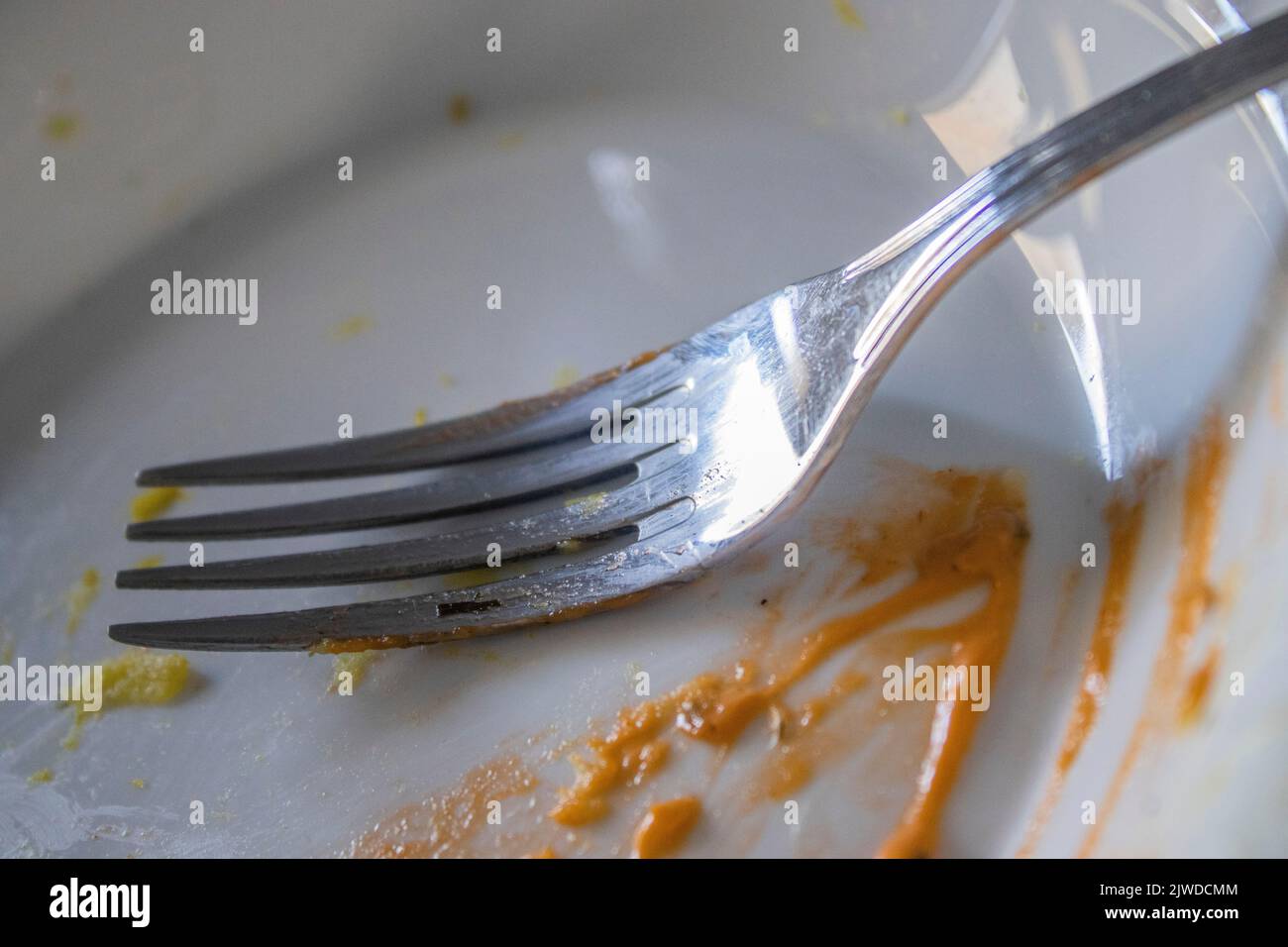 An empty plate with a fork after eat Stock Photo - Alamy