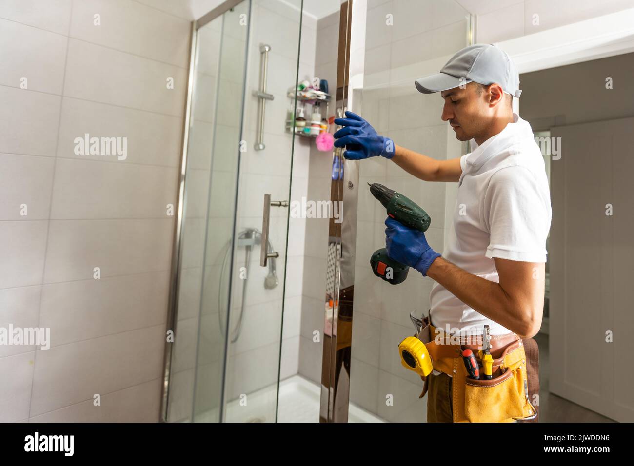 Young plumber fixing shower cabin Stock Photo - Alamy