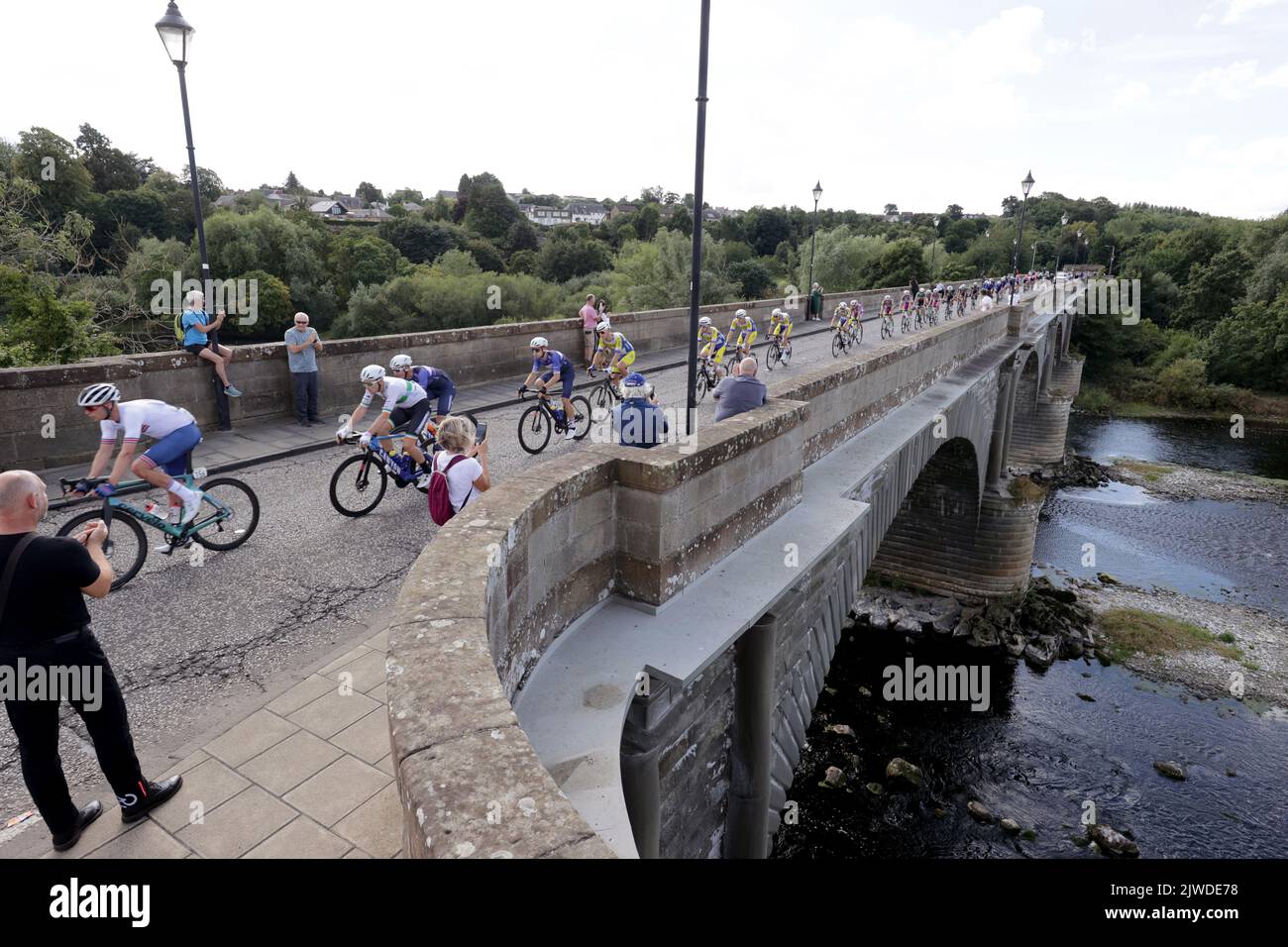 Riders cycle over Kelso Bridge across the River Tweed at Kelso, in the ...