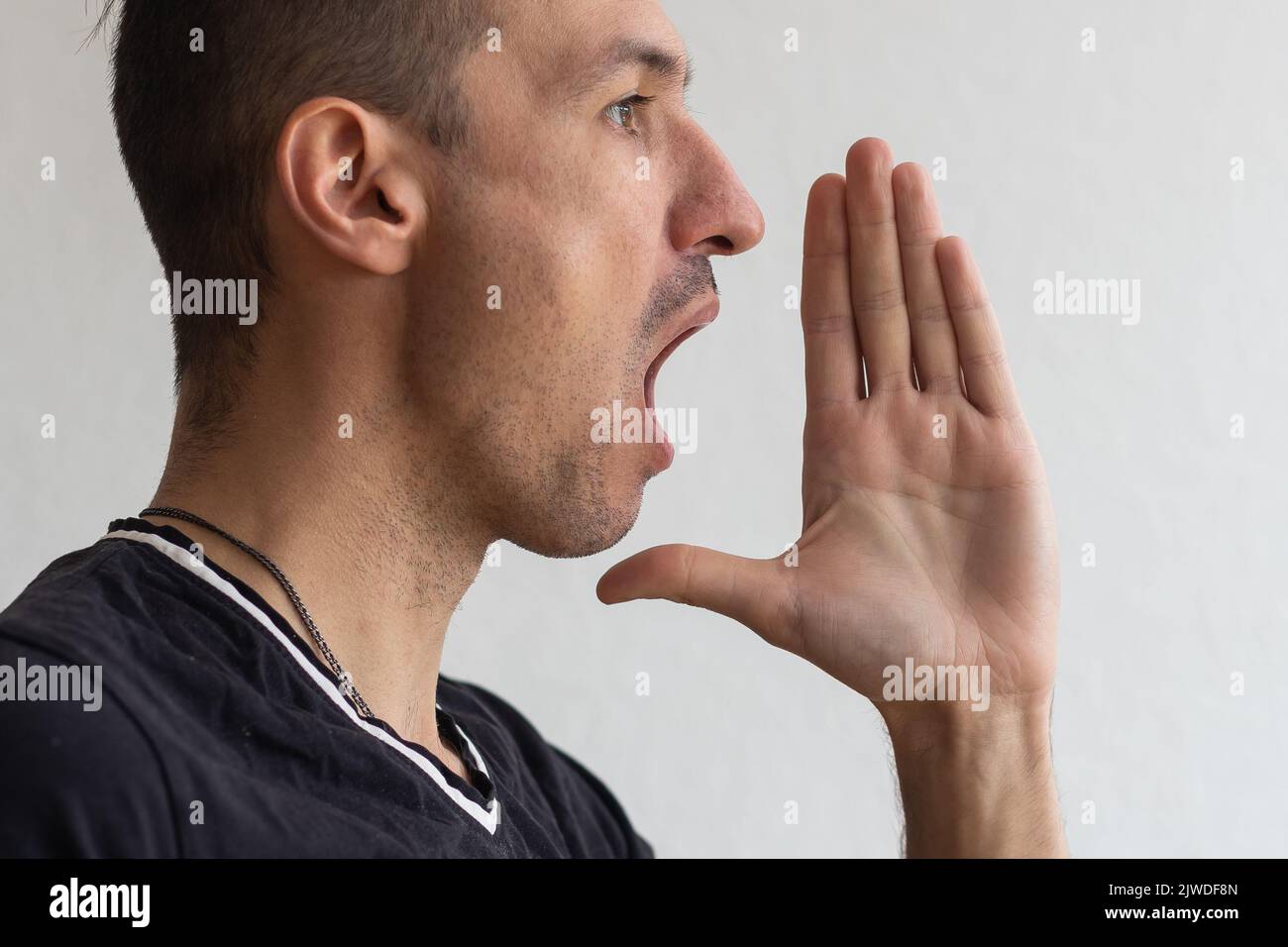 Handsome happy man wearing T-shirt, guy speaking loudly, isolated on ...