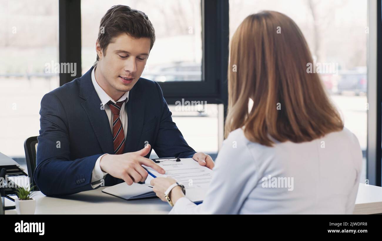 man pointing at resume during job interview with businesswoman in ...