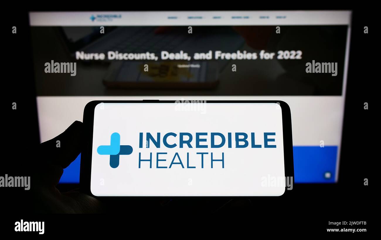 Person holding smartphone with logo of US nurse hiring company ...