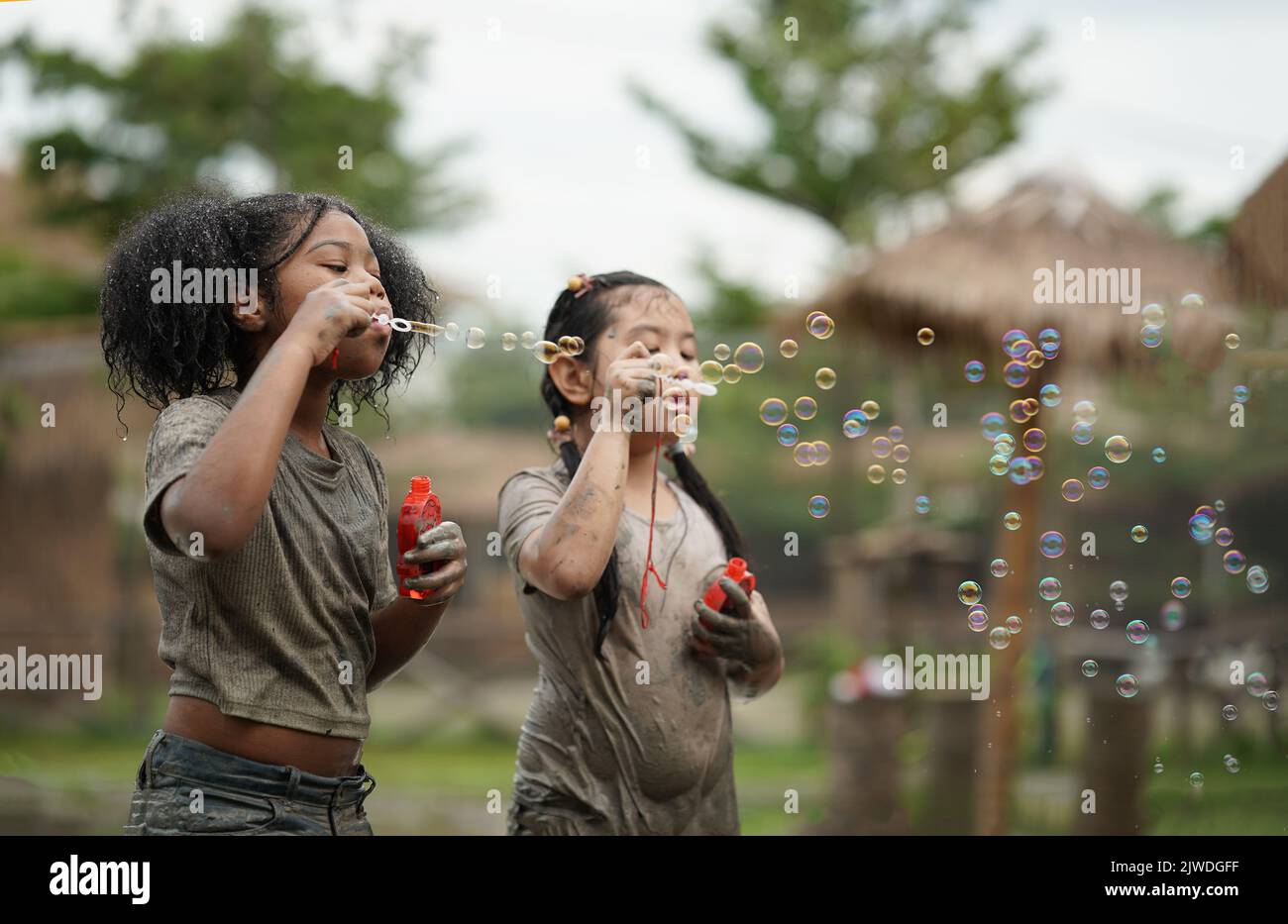 Group of kids playing on muck in the raining day Stock Photo - Alamy