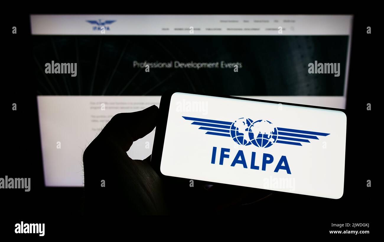 Person holding mobile phone with logo of international pilot ...