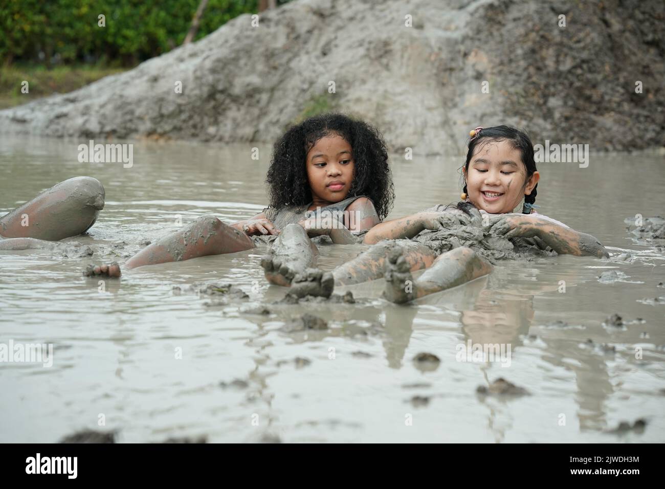 Group of kids playing on muck in the raining day Stock Photo - Alamy