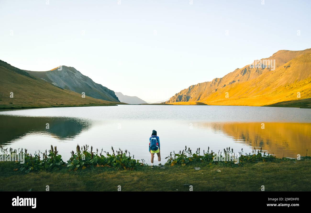 Female caucasian woman hiker stand enjoy peaceful lake panorama in ...