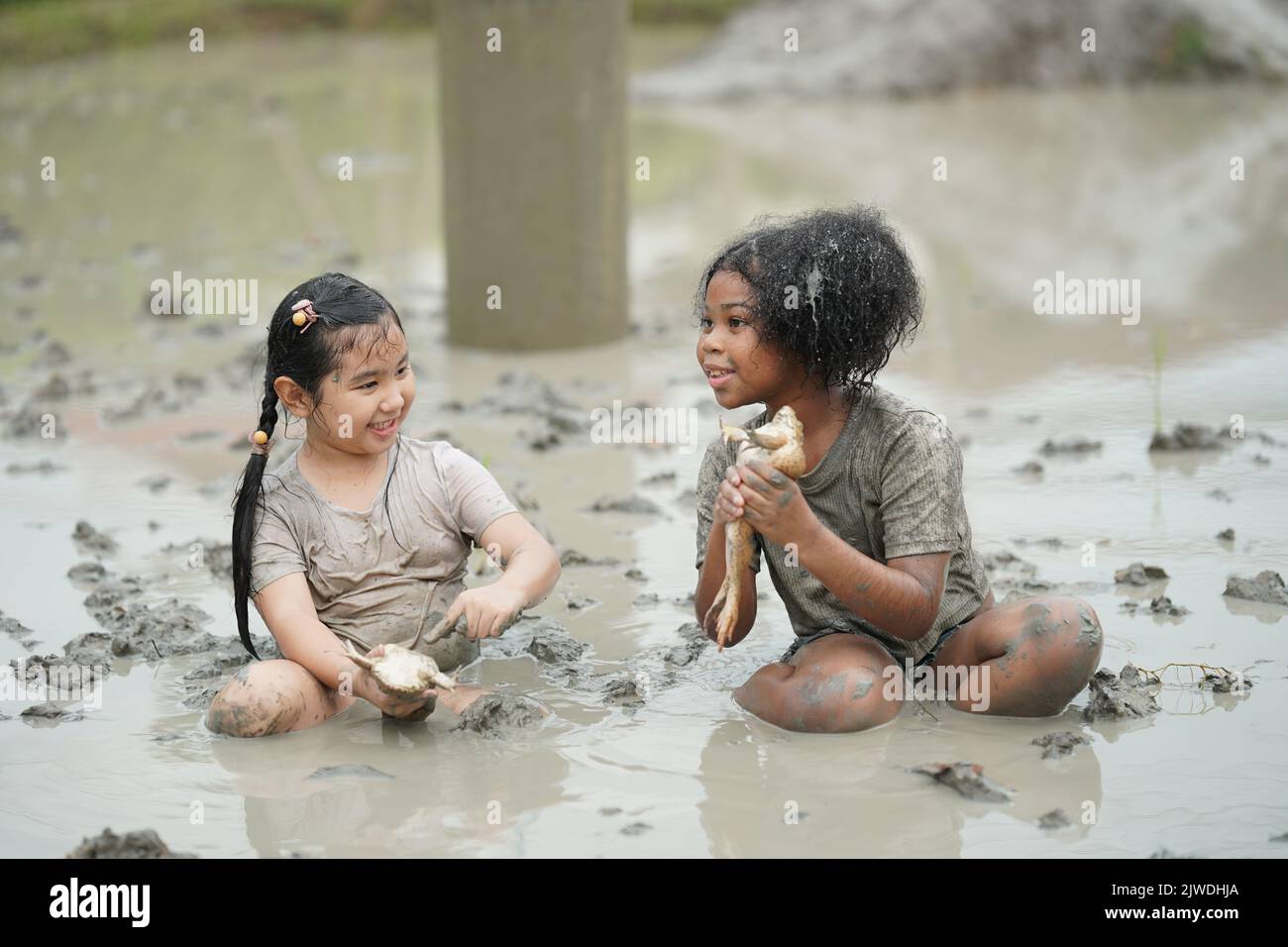 Group of kids playing on muck in the raining day Stock Photo - Alamy