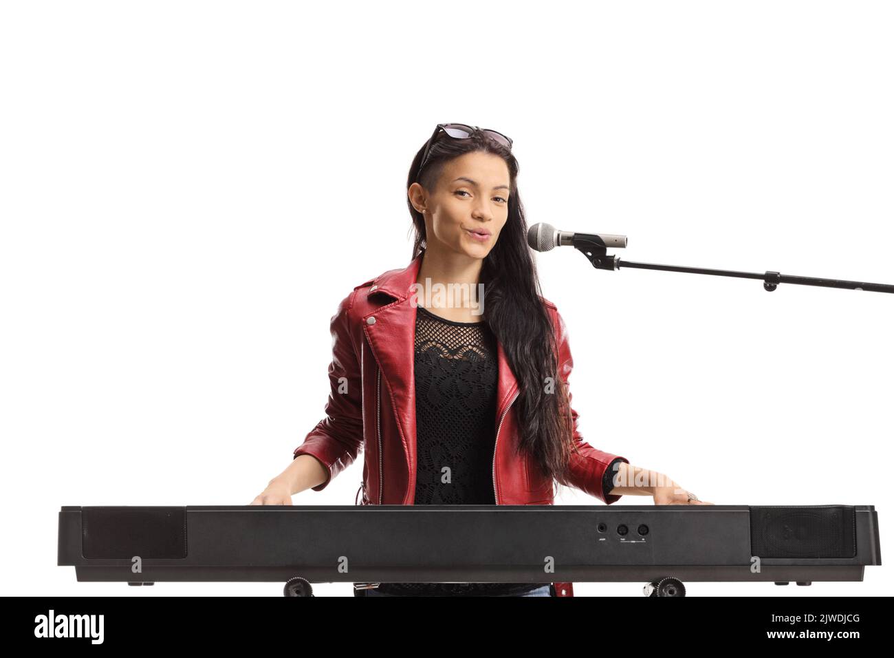 Young female musician playing a keyboard and singing isolated on white ...