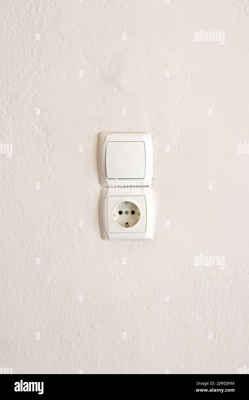 Socket and light switch isolated on white wall background. Electrical ...