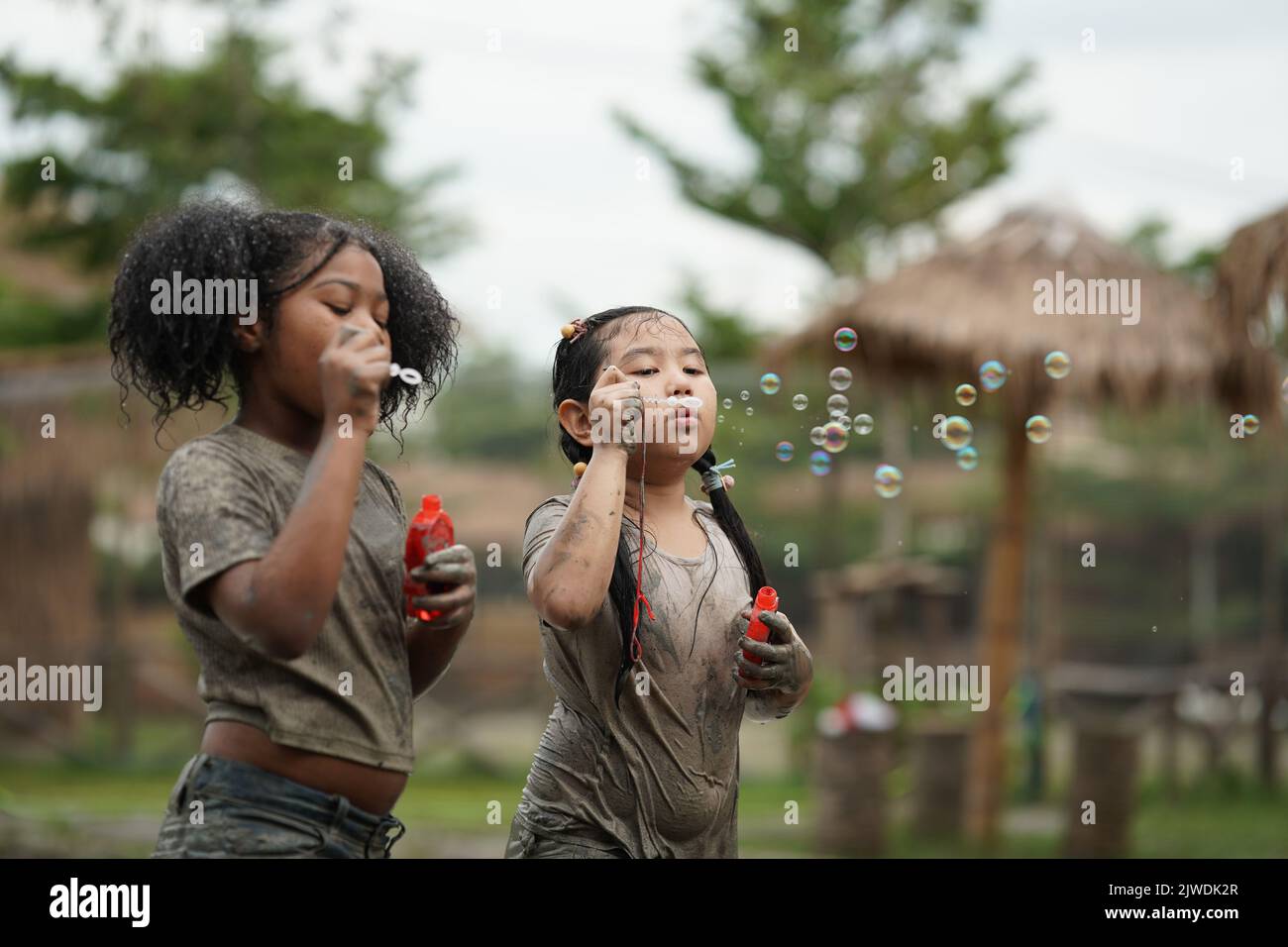 Group of kids playing on muck in the raining day Stock Photo - Alamy