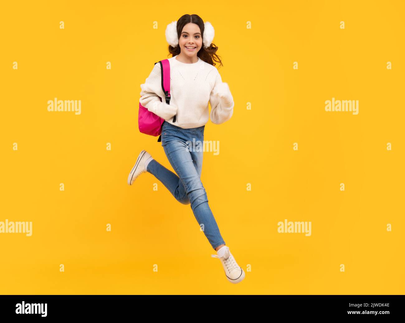 Back to school. Teenager schoolgirl with warm hat and sweater on yellow ...