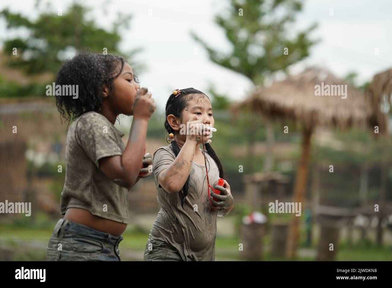 Group of kids playing on muck in the raining day Stock Photo - Alamy