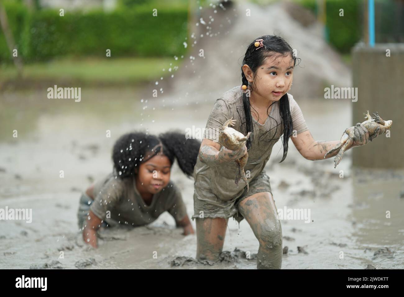 Group of kids playing on muck in the raining day Stock Photo - Alamy