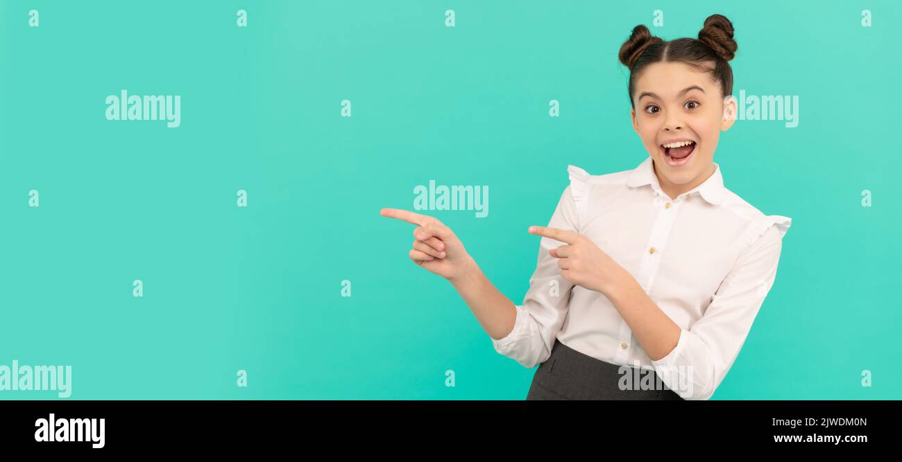 Happy primary school kid point fingers hand gesture for product ...