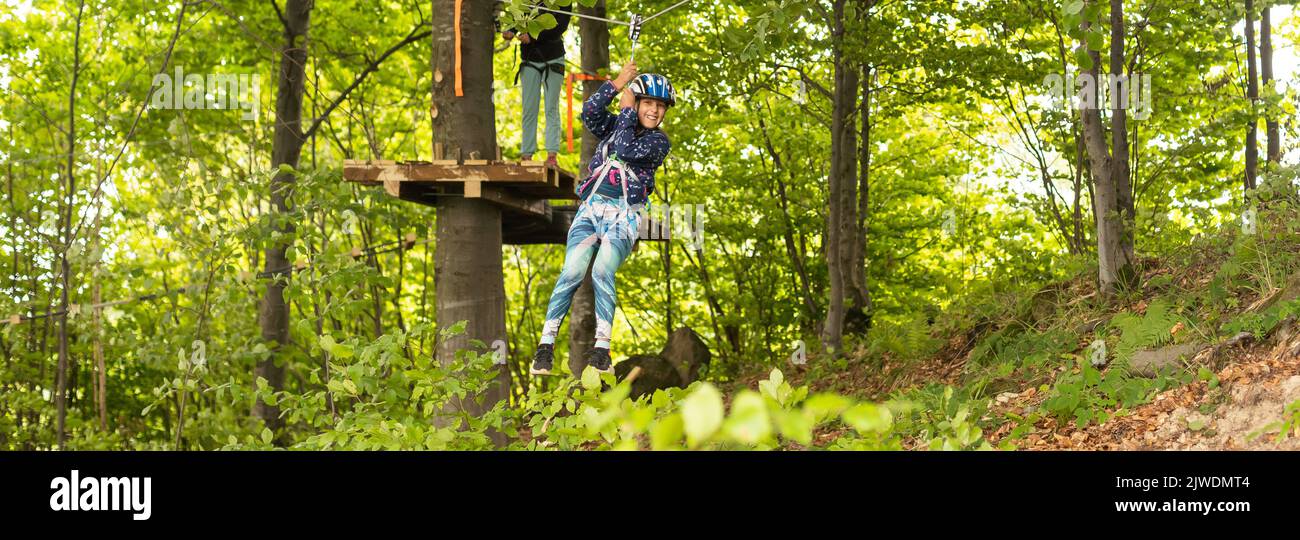Little girl preschooler wearing full climbing harness having fun time ...