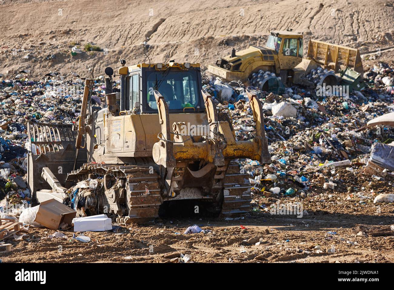 Heavy machinery shredding garbage in an open air landfill. Waste Stock ...