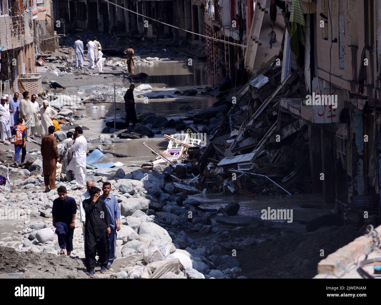 Swat. 5th Sep, 2022. Local people are seen at a destroyed market after ...