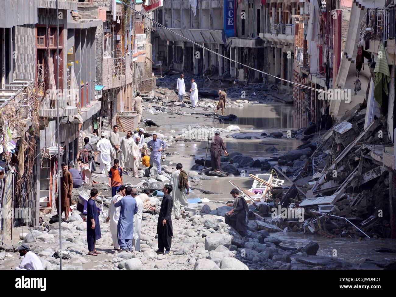 Swat. 5th Sep, 2022. Local people are seen at a destroyed market after ...
