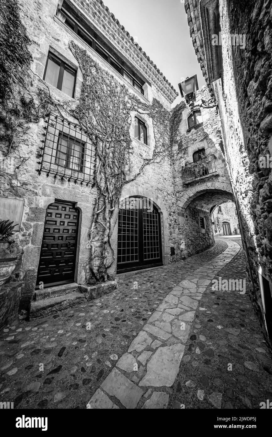 Medieval alley with stone houses and arches in the picturesque town of ...