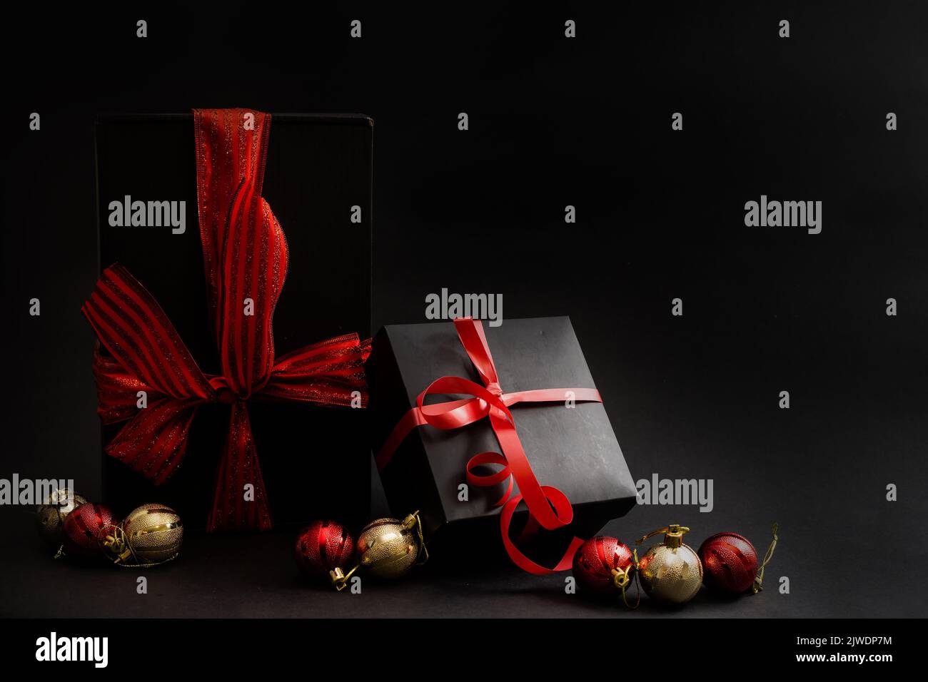 black gift box, balls, red Christmas decorations on the dark wooden ...