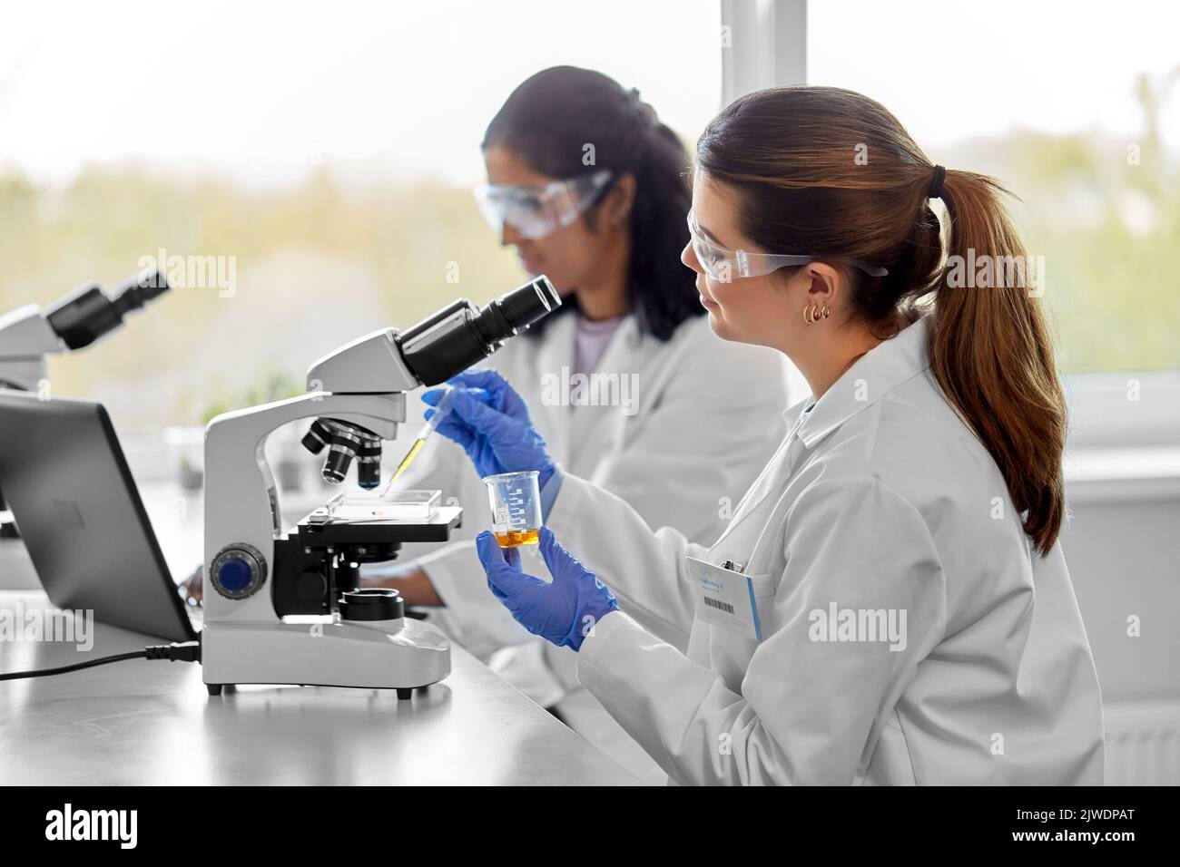 scientists with microscopes working in laboratory Stock Photo - Alamy