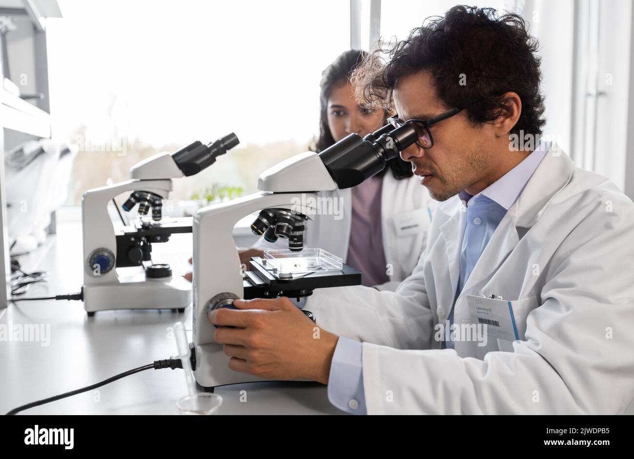 scientists with microscopes working in laboratory Stock Photo - Alamy