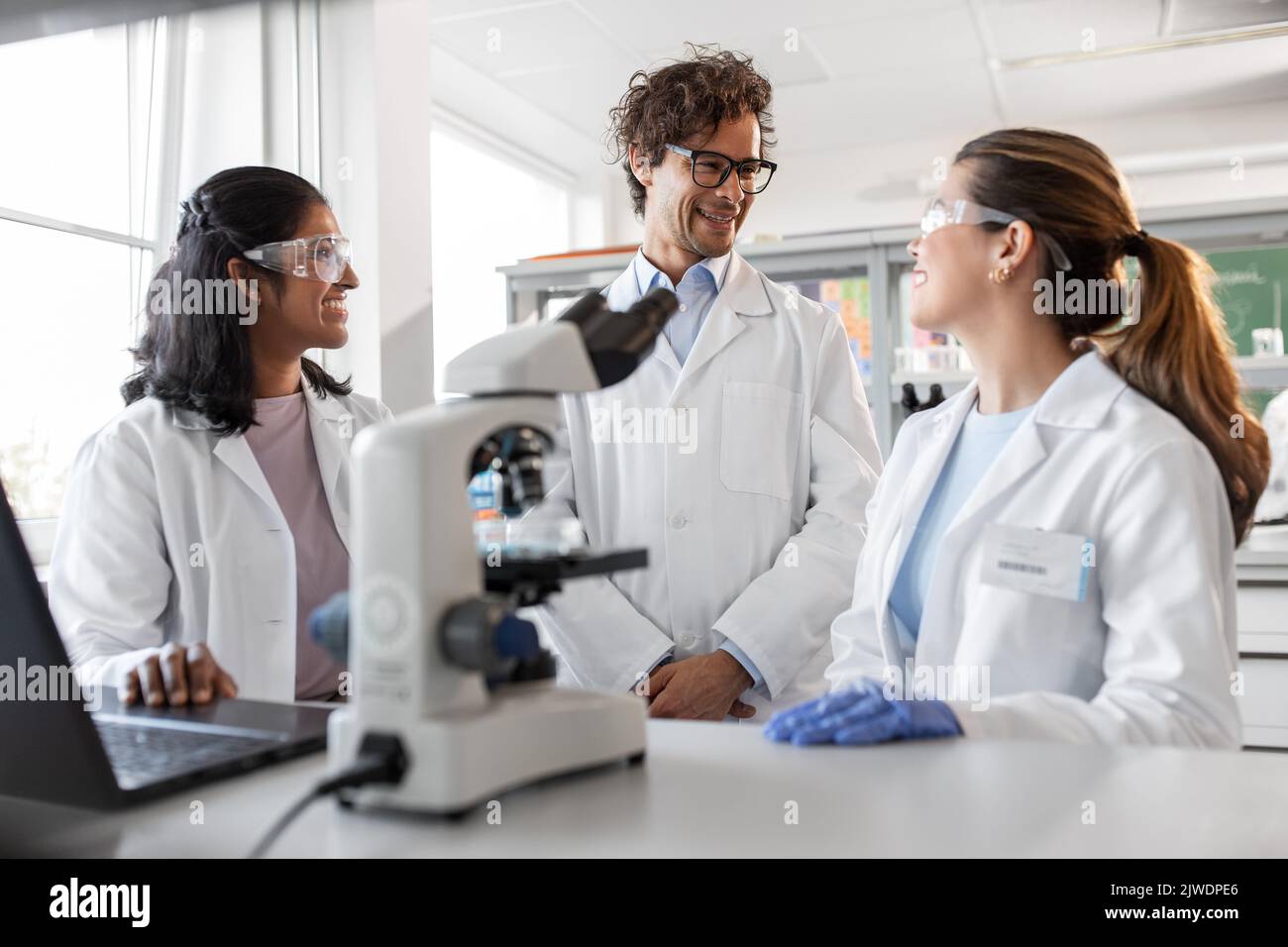 scientists with microscope working in laboratory Stock Photo - Alamy