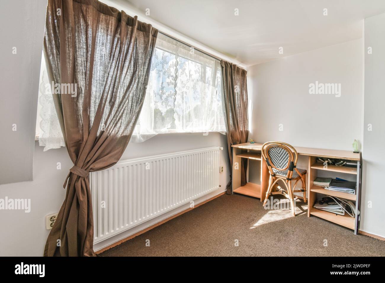 Comfortable bed covered with checkered blanket and located in light ...