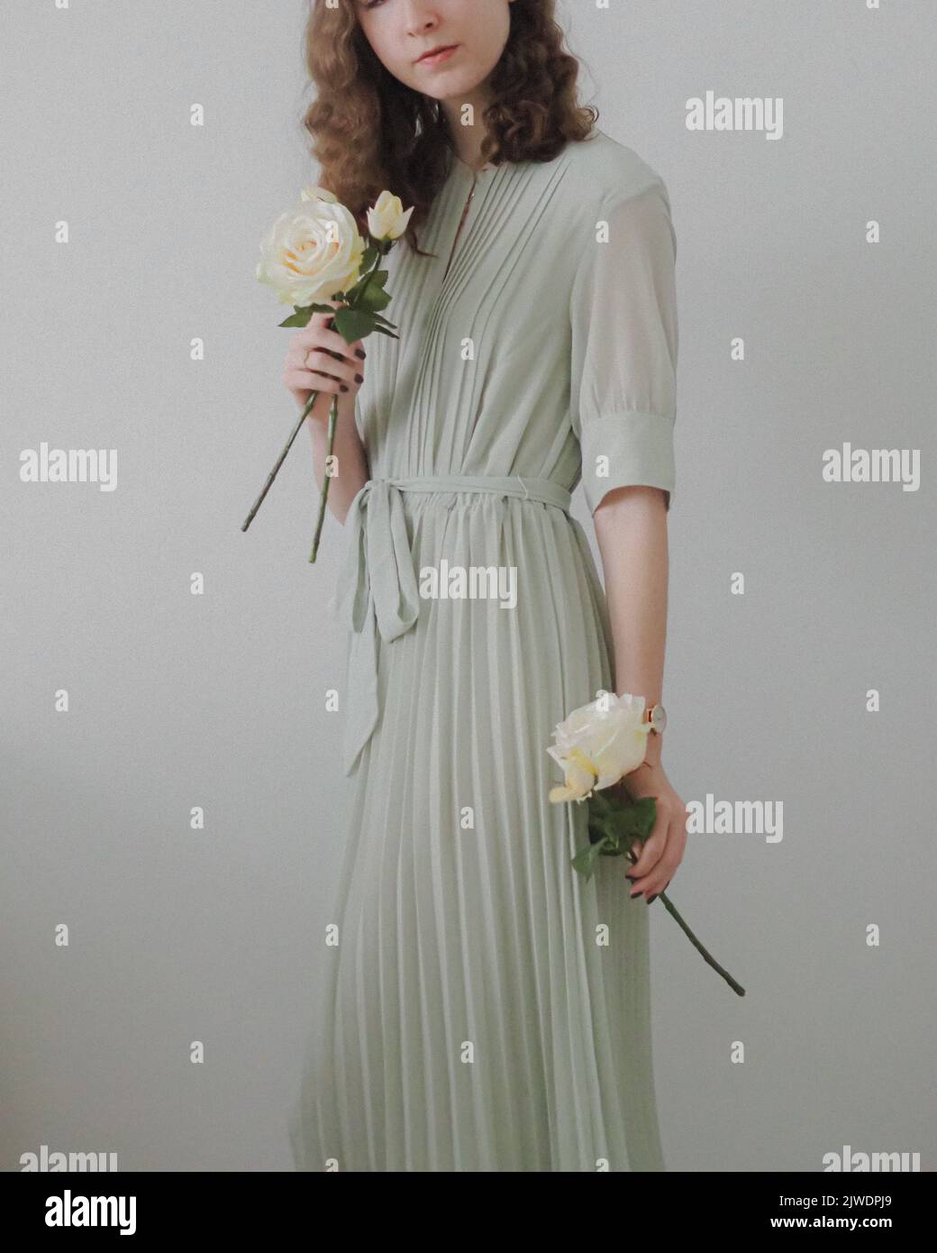 A beautiful Caucasian brunette in Victorian style chiffon dress holding ...
