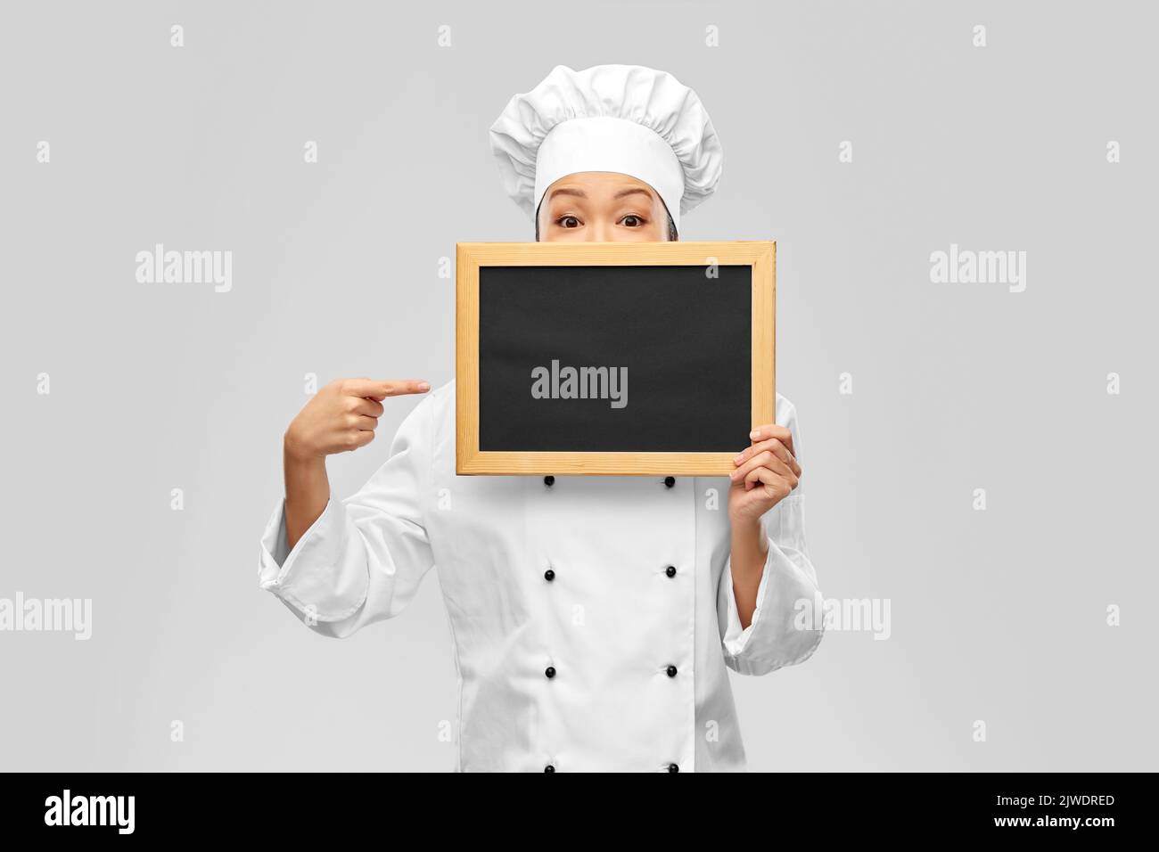 female chef holding black chalkboard Stock Photo - Alamy