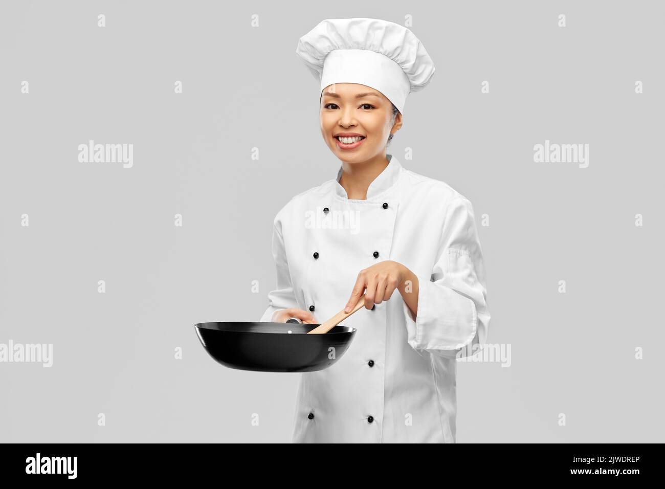 smiling female chef cooking food in frying pan Stock Photo - Alamy