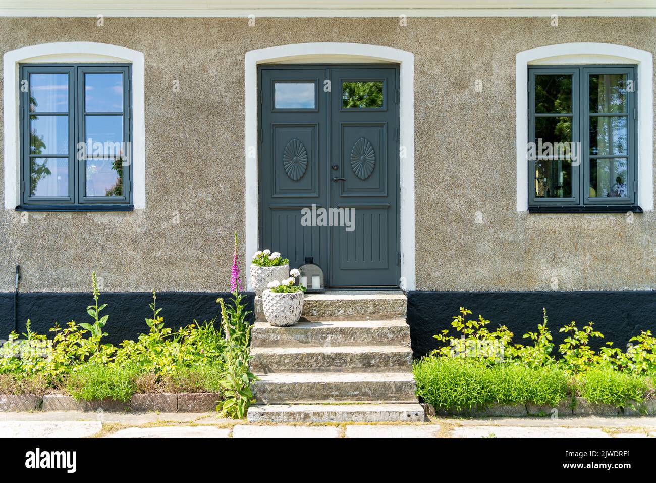 Closed green wooden entrance door with stone stairs and concrete walls ...