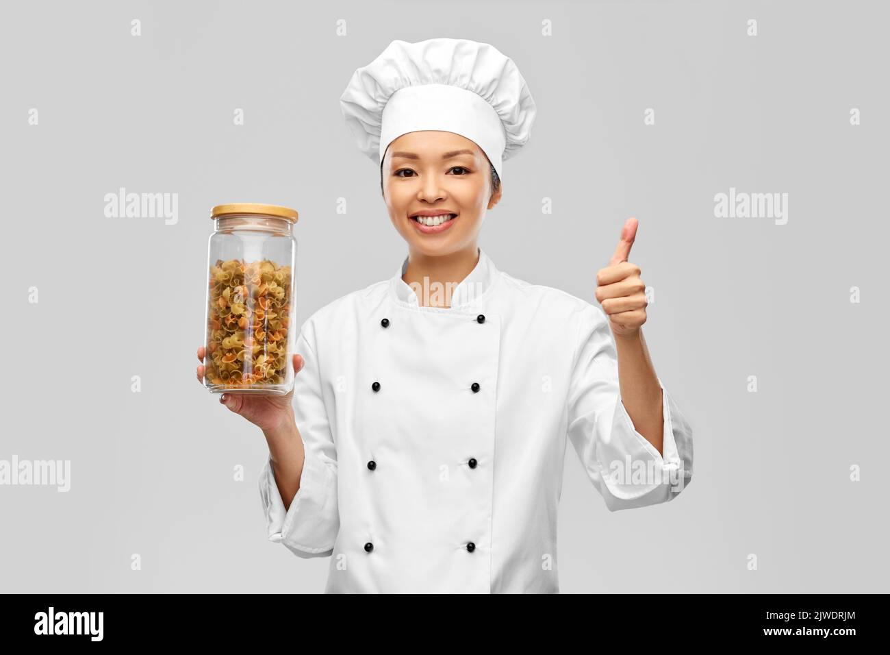 female chef with pasta in jar showing thumbs up Stock Photo - Alamy