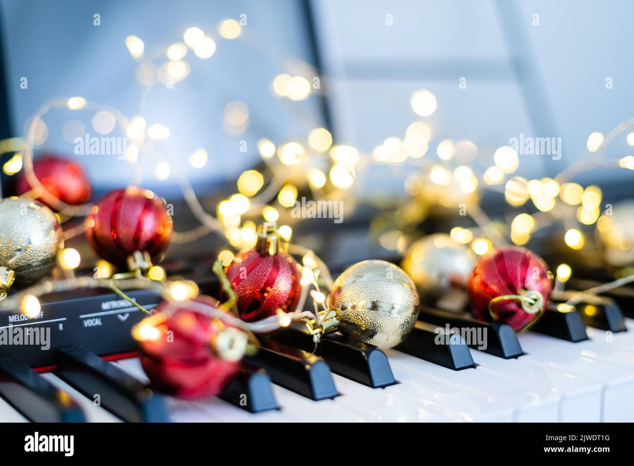 A colorful chain of lights lies on piano keys Stock Photo - Alamy