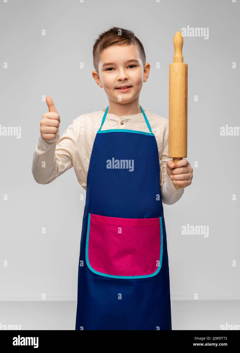 boy in apron with rolling pin showing thumbs up Stock Photo - Alamy