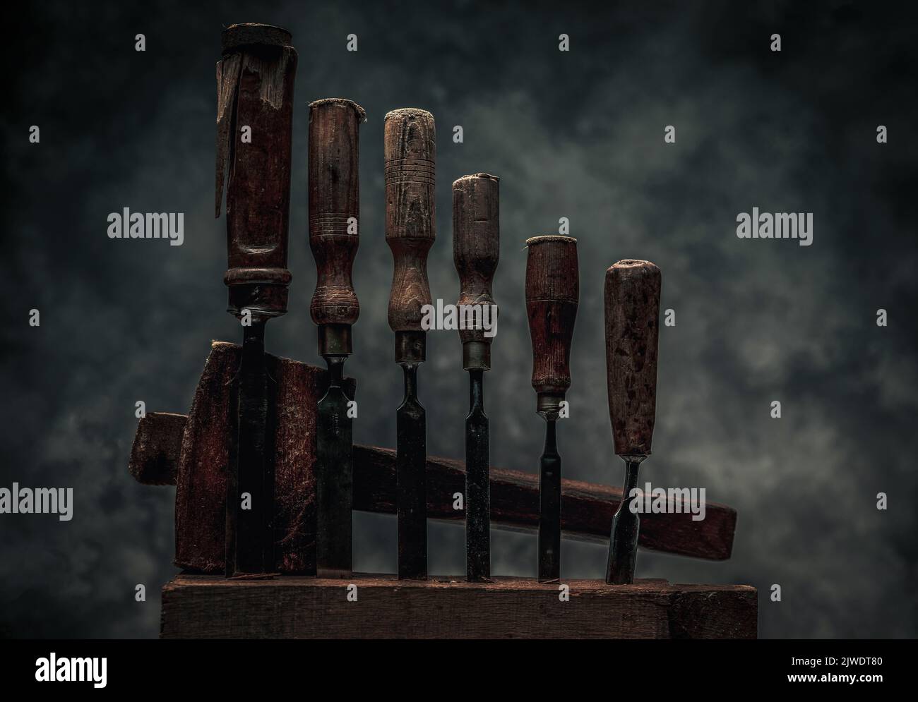 set of carving tools with old rusty hisels and hammer behind on top of ...