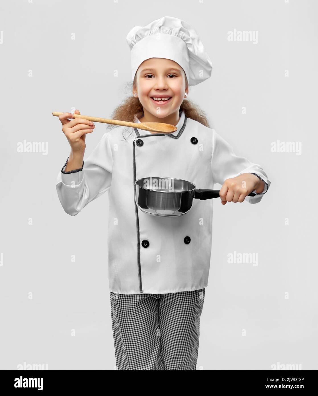 happy girl in chef's toque with spoon and saucepan Stock Photo - Alamy